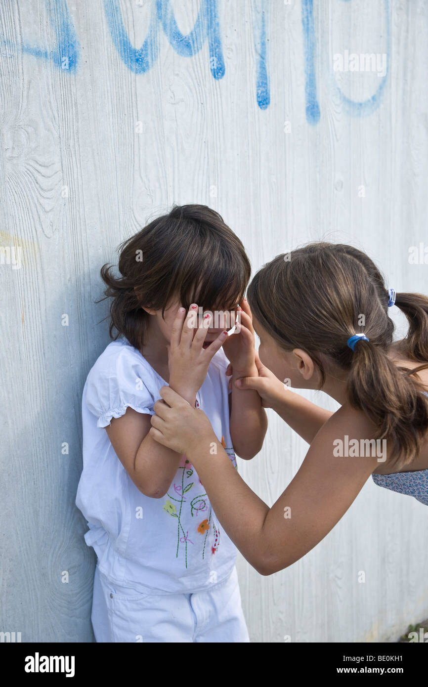 Girl trying to comfort a young crying girl Stock Photo - Alamy