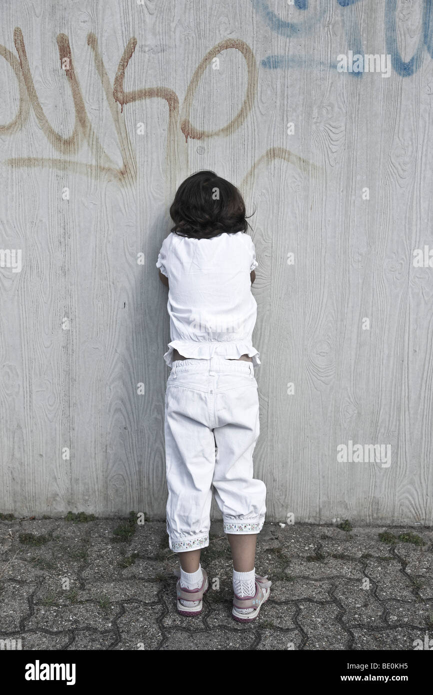 Young girl leaning against a wall, crying Stock Photo - Alamy