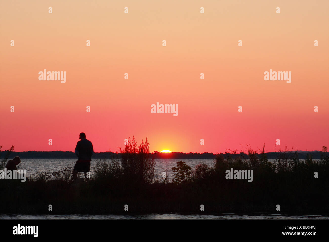 Setting Sun above the Danube dam channel with fishermen, Slovakia Stock ...