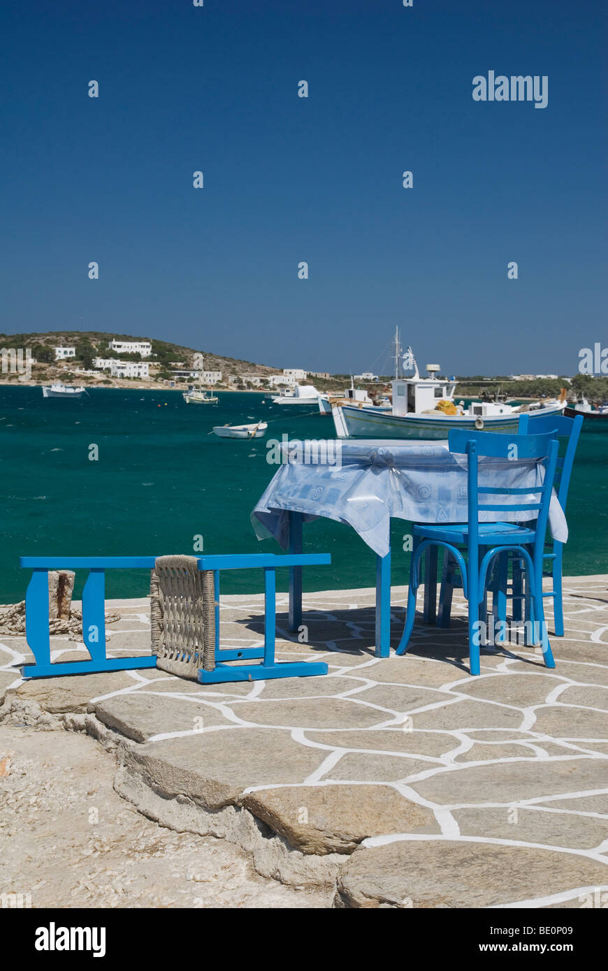 Chair fallen over on side next to a table by the sea in Greece Stock ...