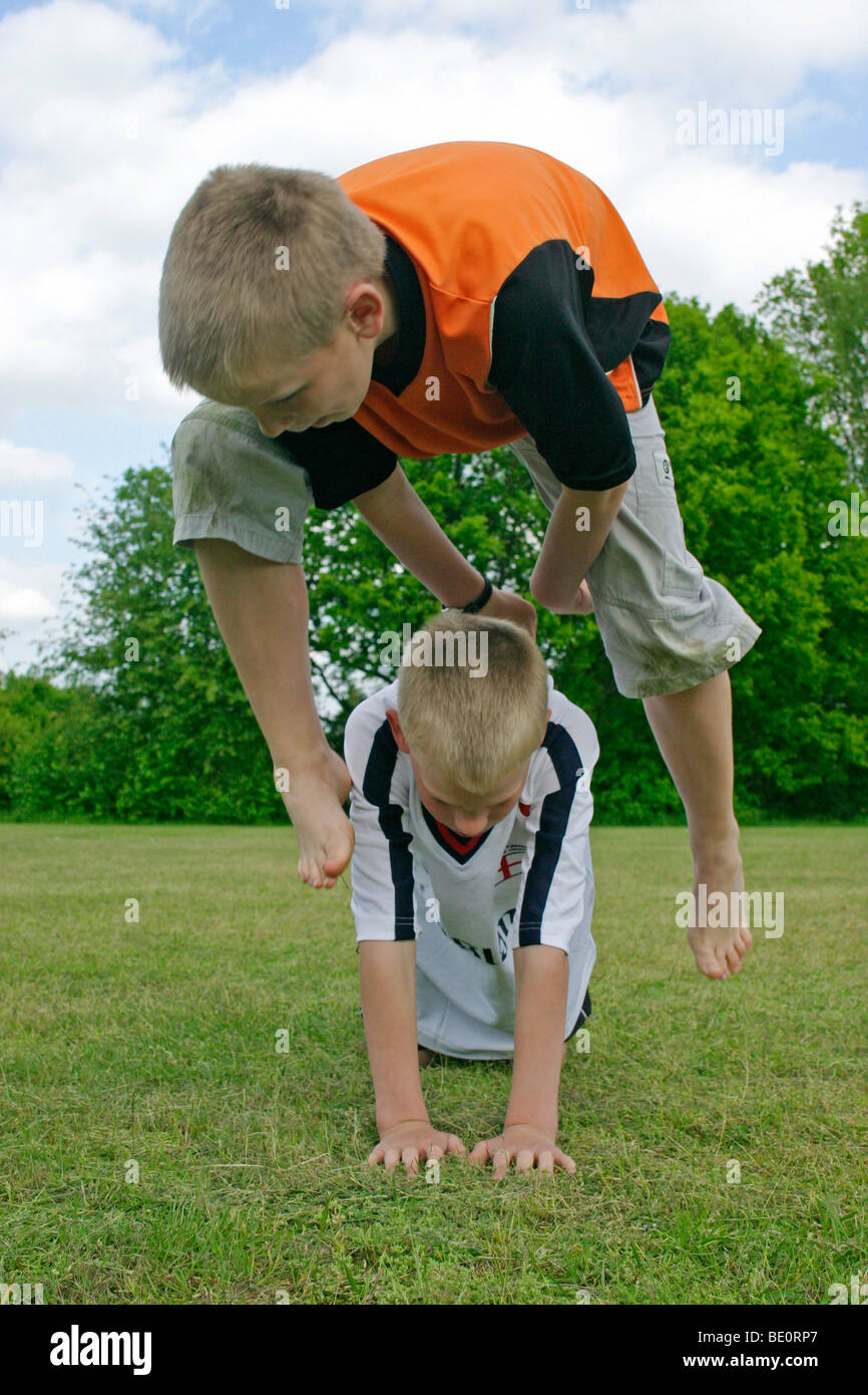 two young boys playing leapfrog Stock Photo - Alamy