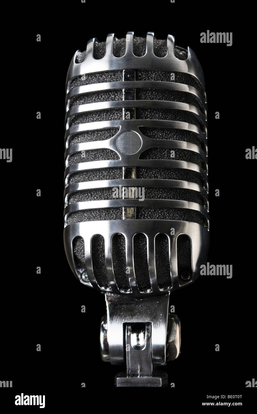 Vintage microphone in close-up view isolated over a black background ...
