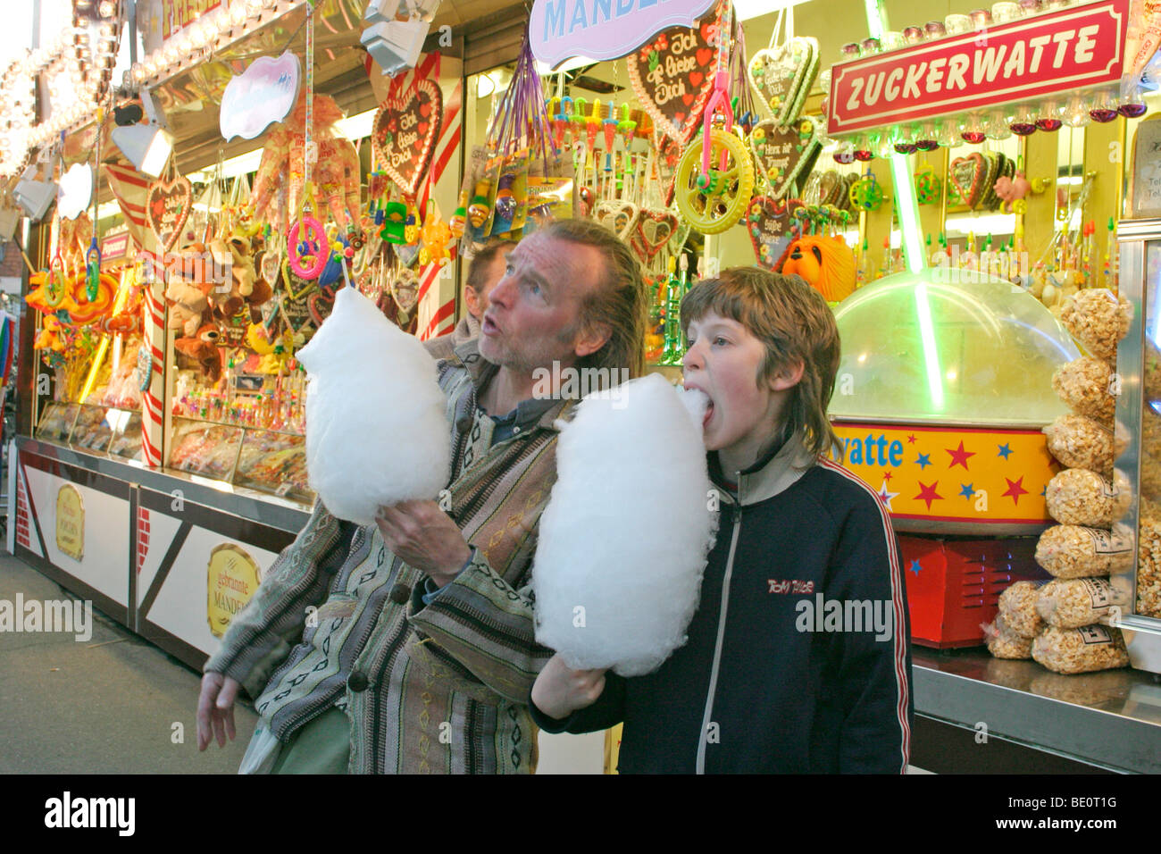 a young boy and his father eating candy floss at a fun fair Stock Photo ...