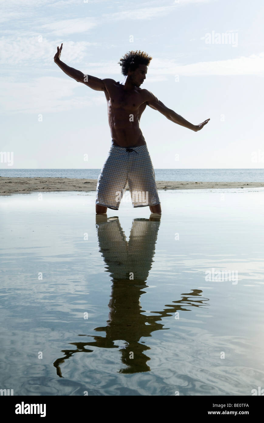 Man with outstretched arms wading in water at seashore Stock Photo - Alamy
