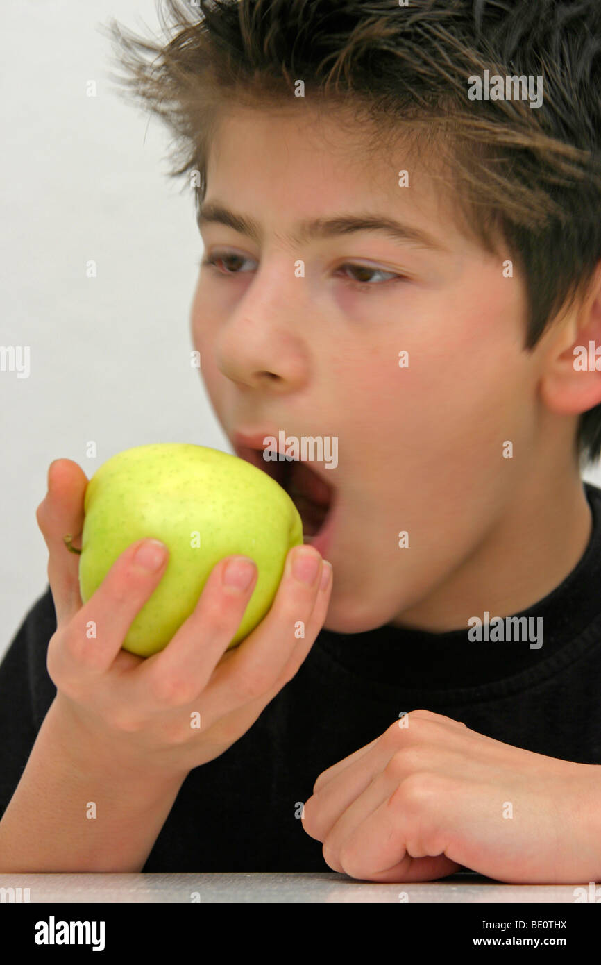 portrait of a young boy eating an apple Stock Photo - Alamy