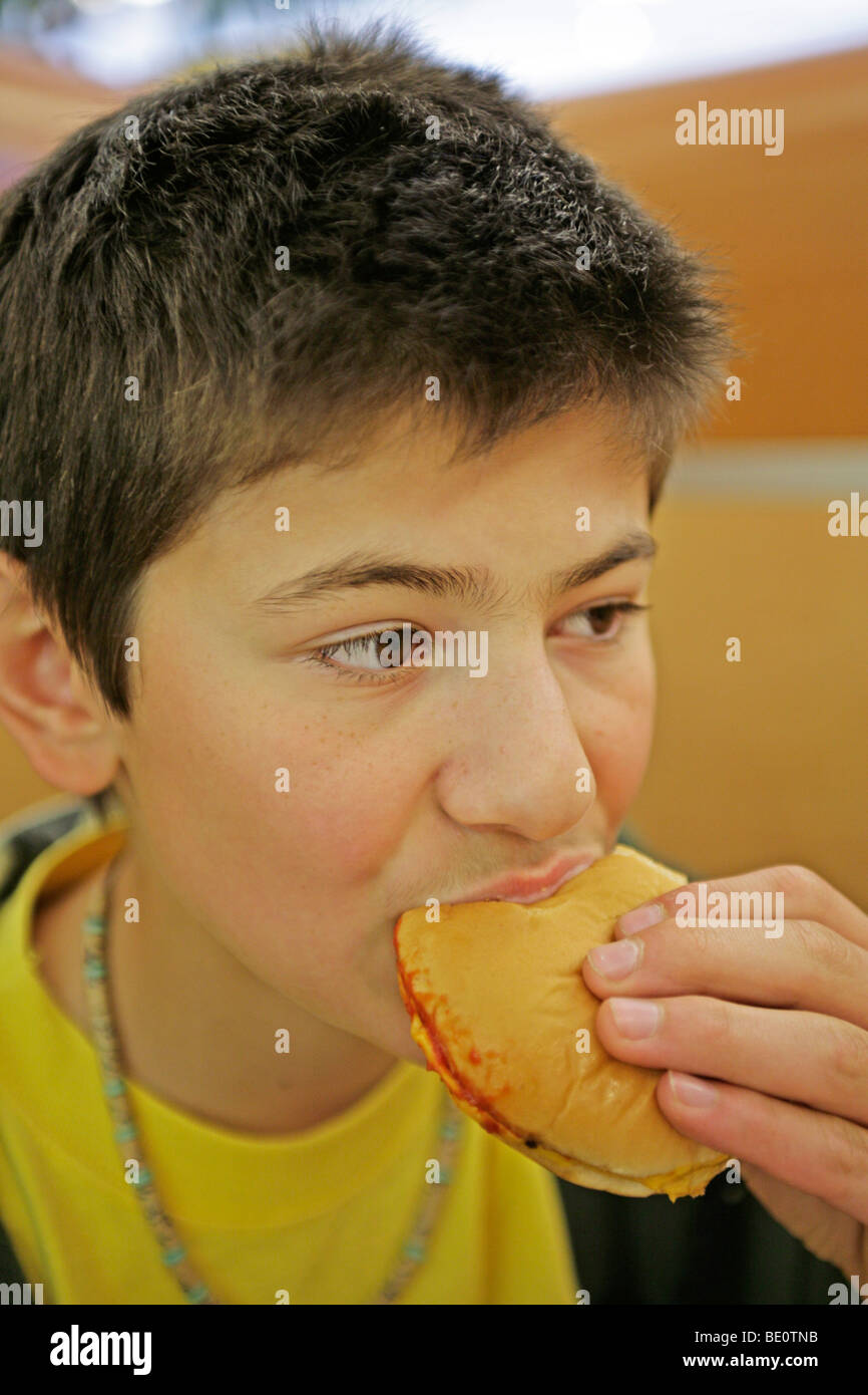 portrait of a young boy eating a hamburger Stock Photo - Alamy