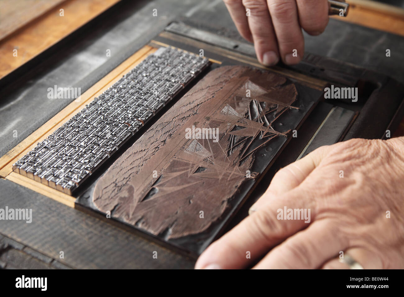 printer tightens metal type and a cut into a chase Stock Photo - Alamy