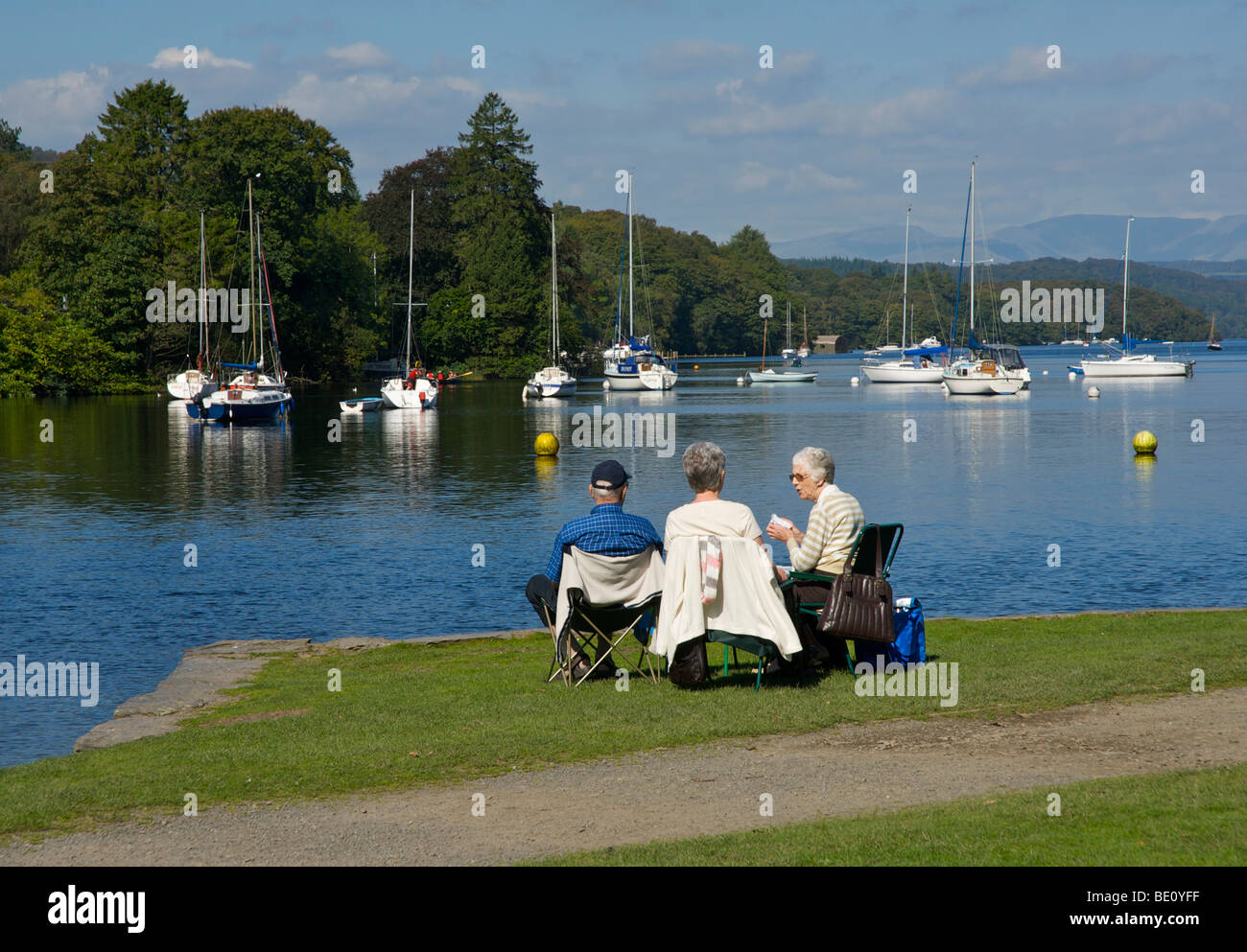 Three people relaxing in Fell Foot Park, Lake Windermere, Lake District ...