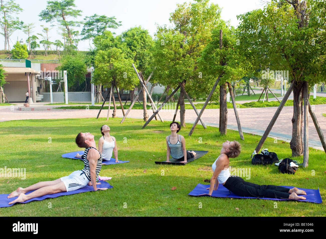 Group Of People Practicing Yoga Outdoors In Park Stock Photo - Alamy