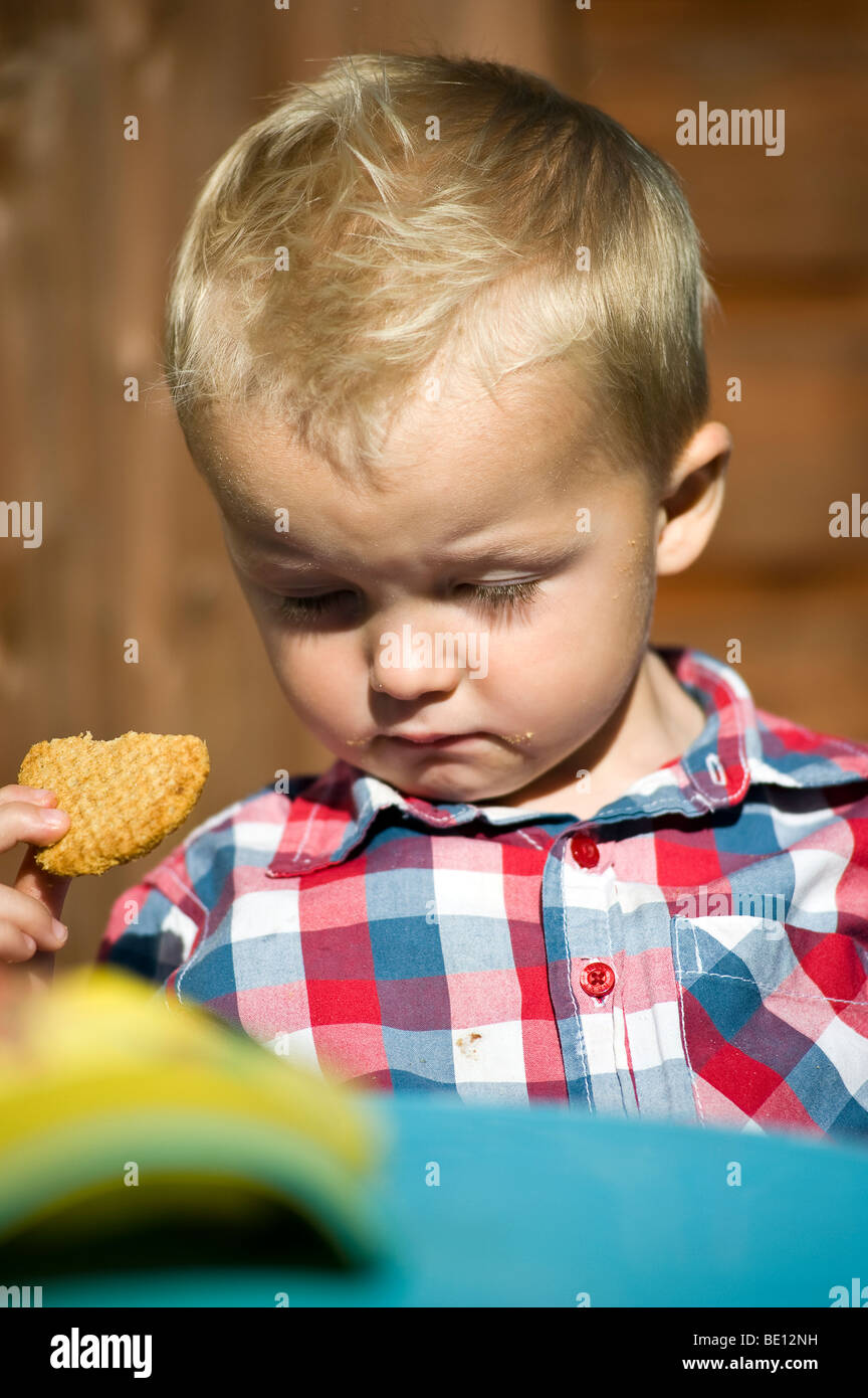 Two year old boy eating a snack Stock Photo - Alamy