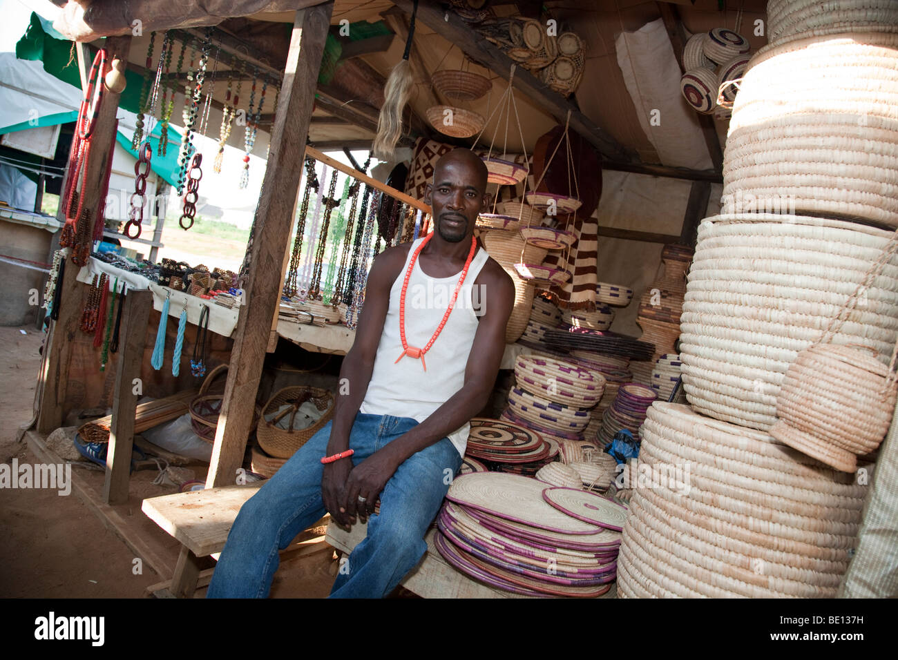 A Fulani man sells handicrafts, including woven baskets and calabash ...
