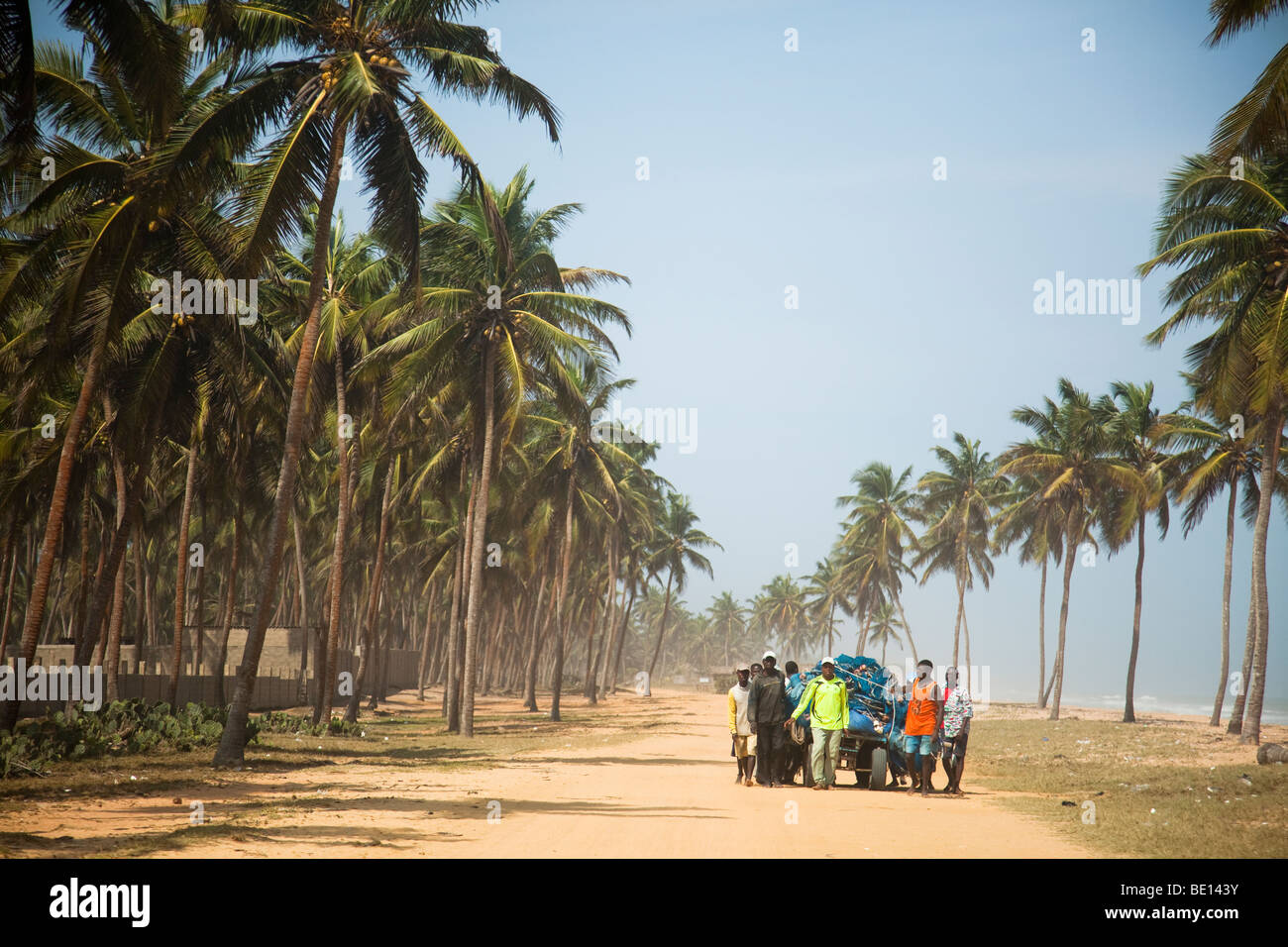 A colorfully painted fishing boat rests on the beach between Benin's ...