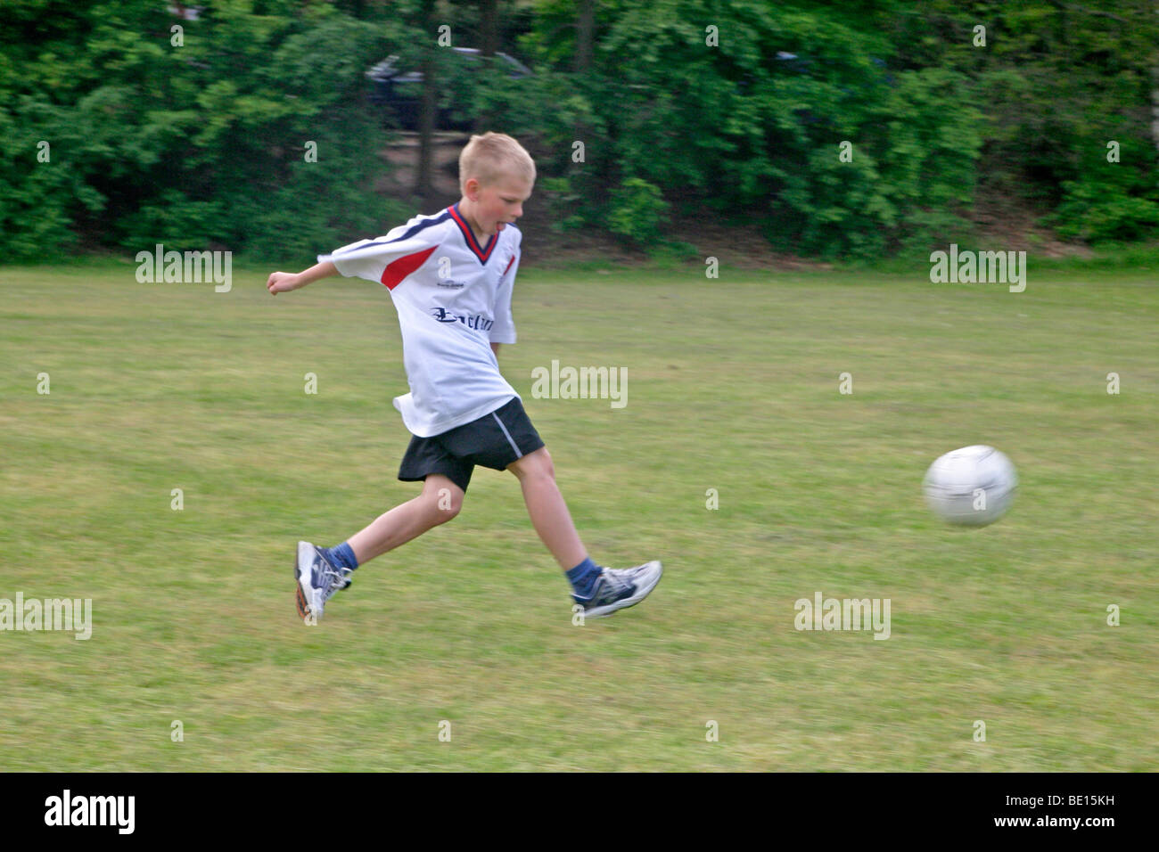 young boy playing football Stock Photo - Alamy