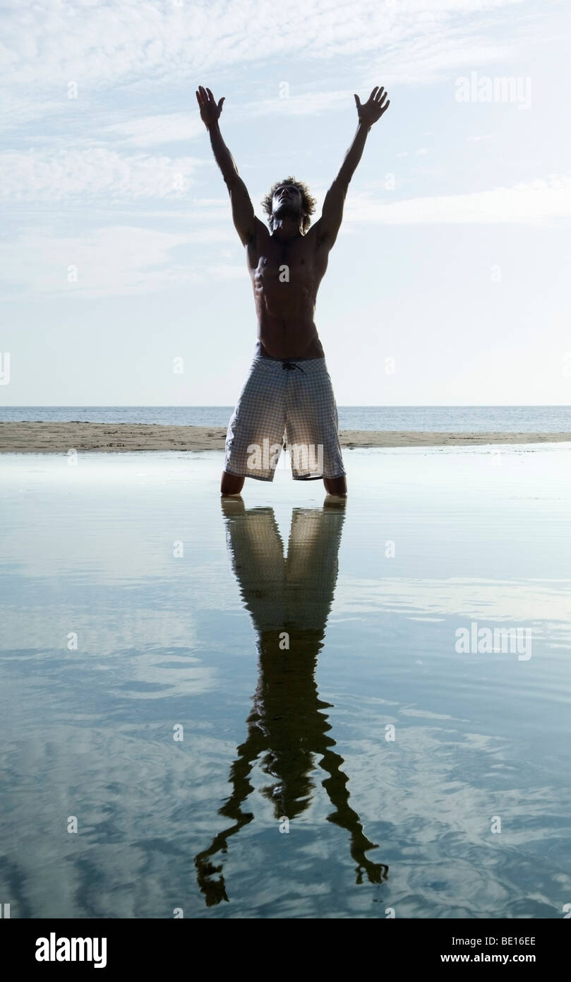 Man with outstretched arms wading in water at seashore Stock Photo - Alamy