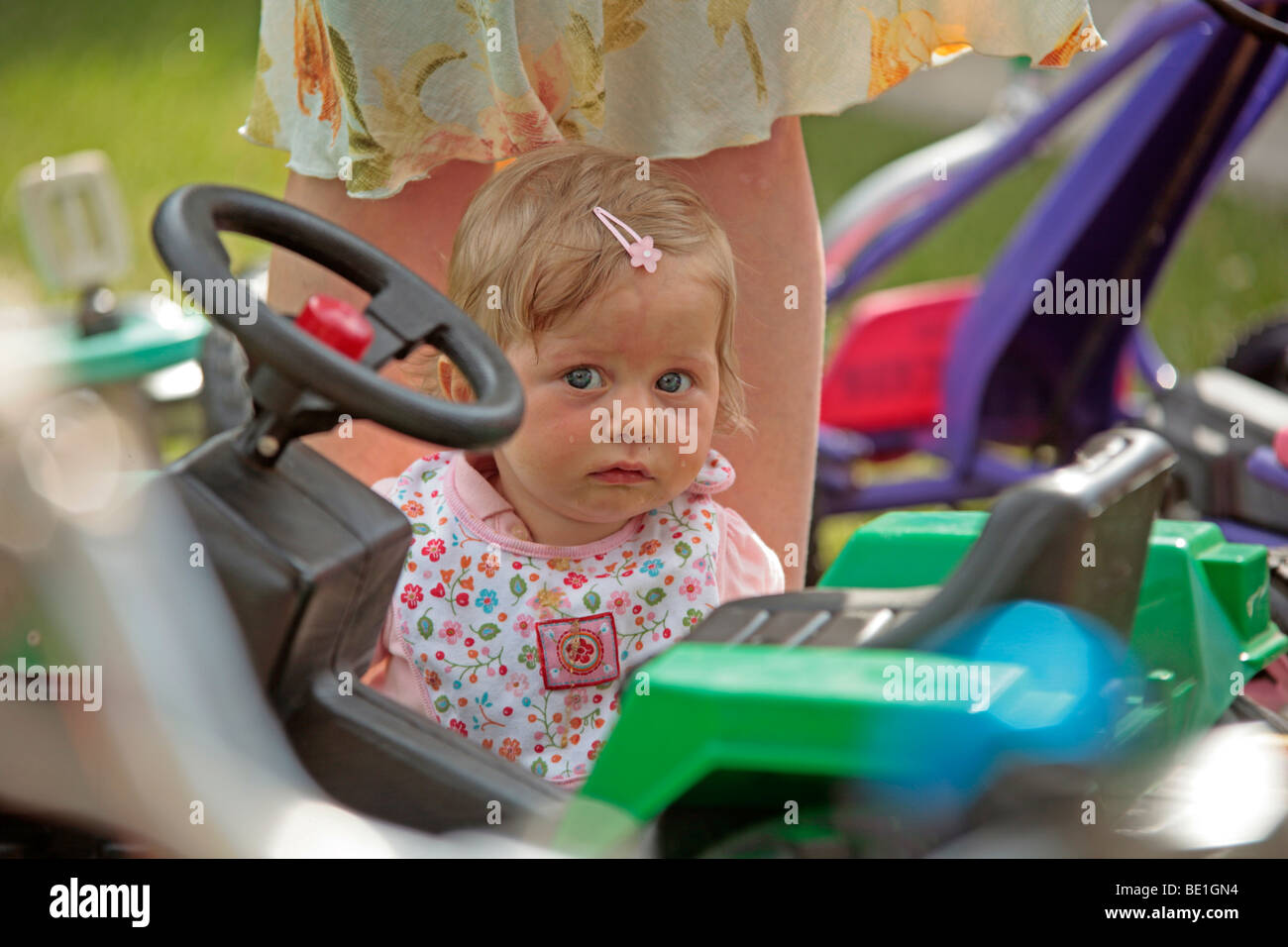 portrait of a curious baby girl standing beside her mother Stock Photo ...