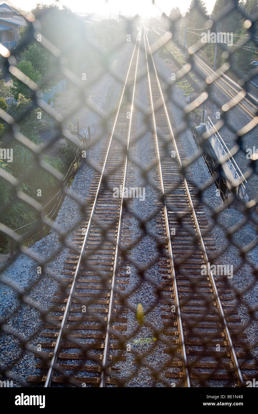 Train tracks viewed from a pedestrian overpass. The wire fence is for ...