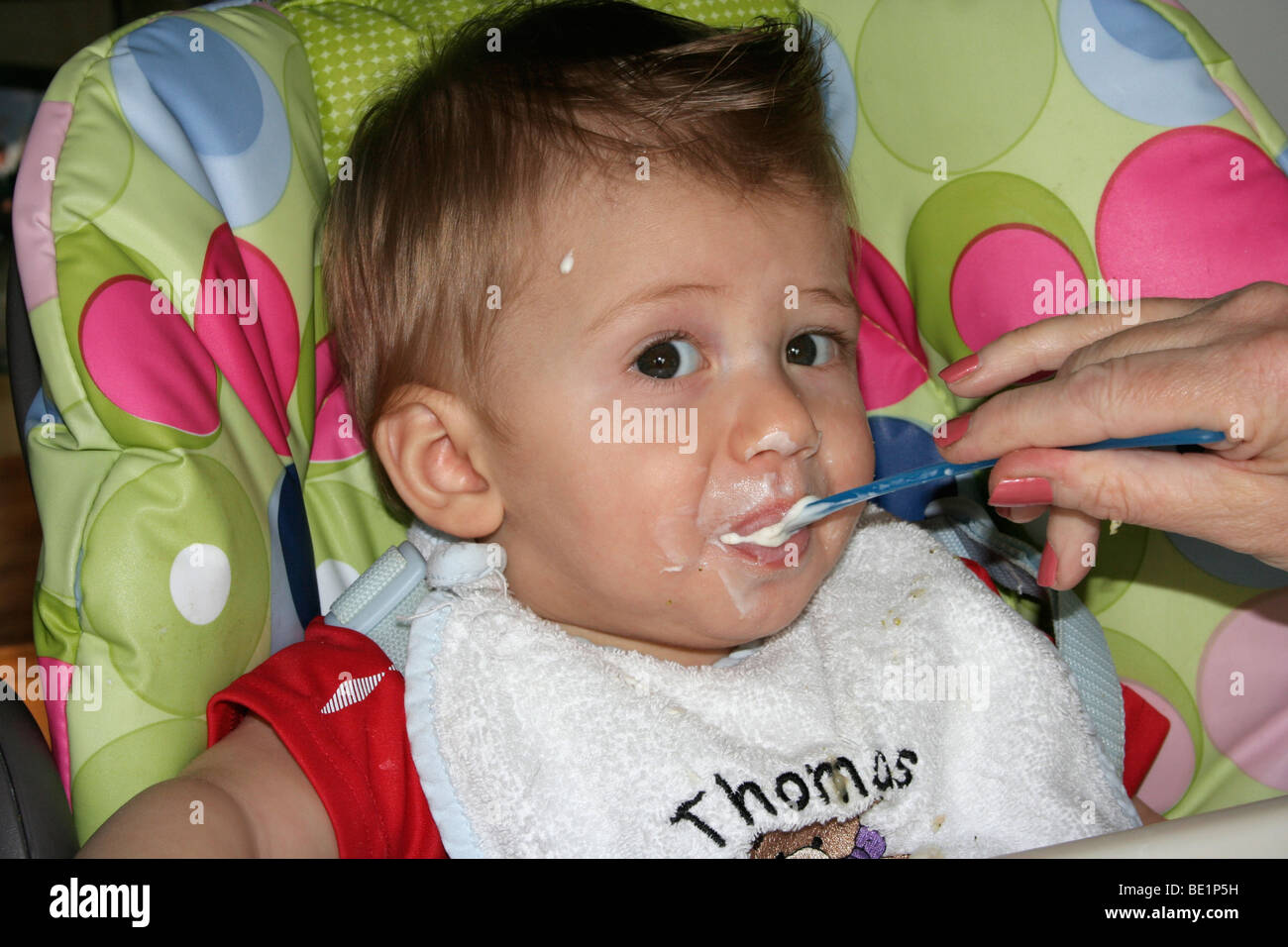 Young boy being spoon fed Stock Photo - Alamy