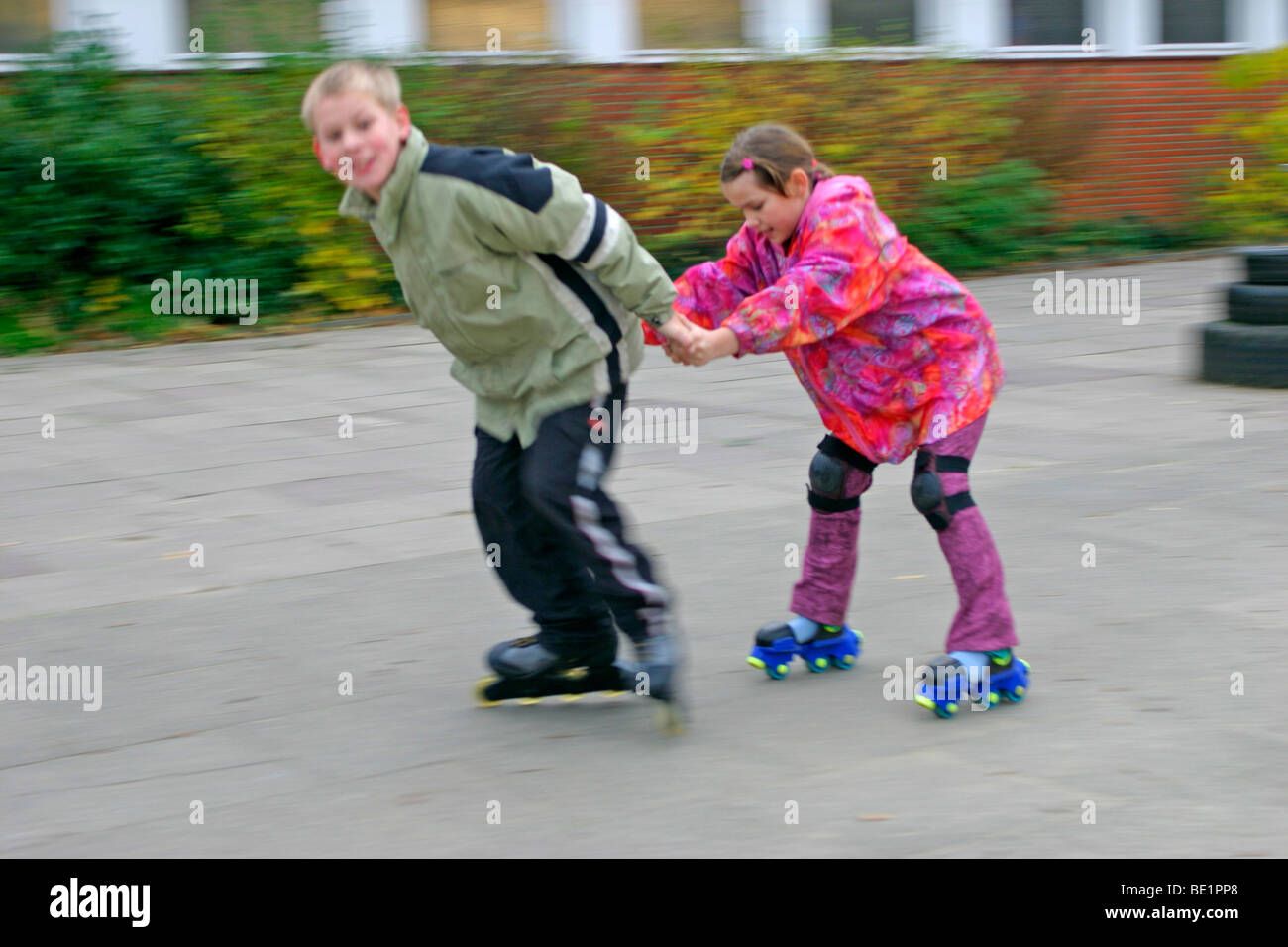 big brother helping his younger sister at in-line skating Stock Photo ...