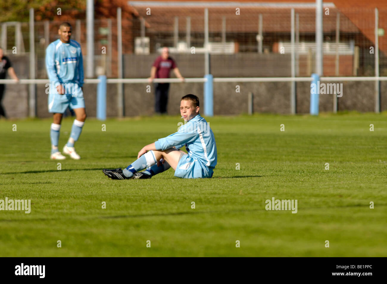 football player sits and spits after being brought down Stock Photo - Alamy