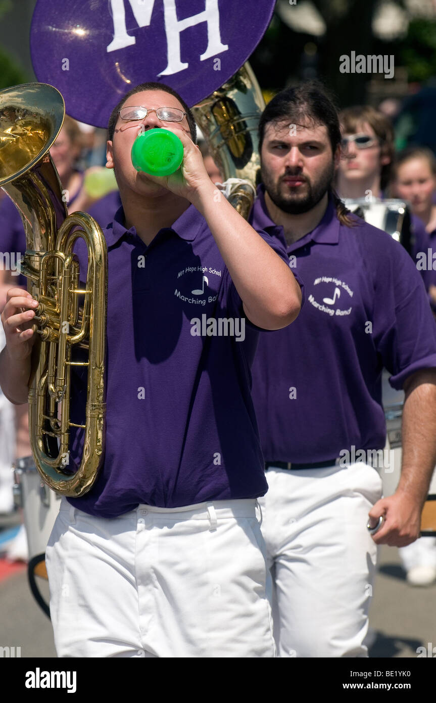 Young man taking a drink of water while marching in Bristol Rhode ...