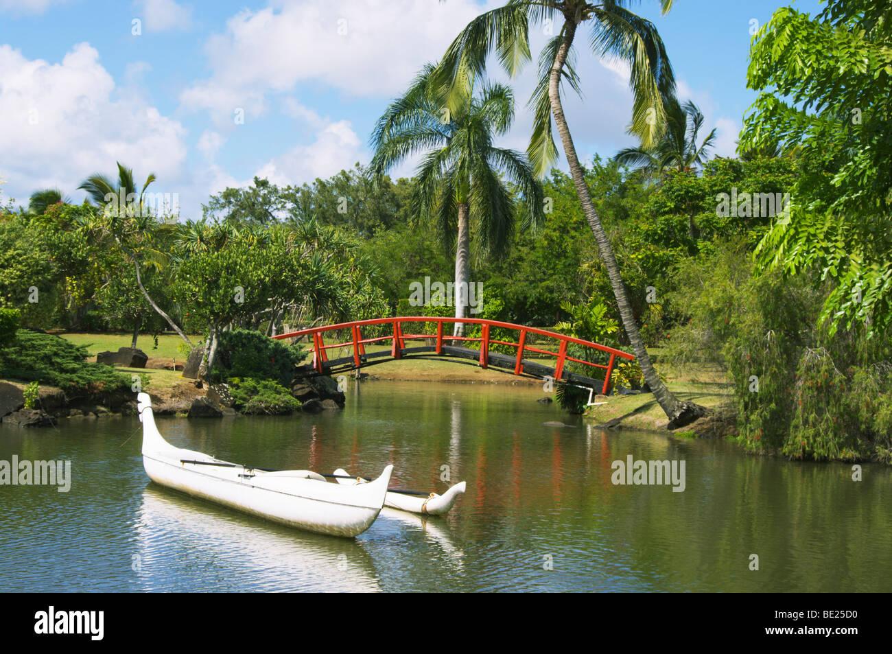 White outrigger canoe and red wooden Japanese bridge at Smiths Tropical ...