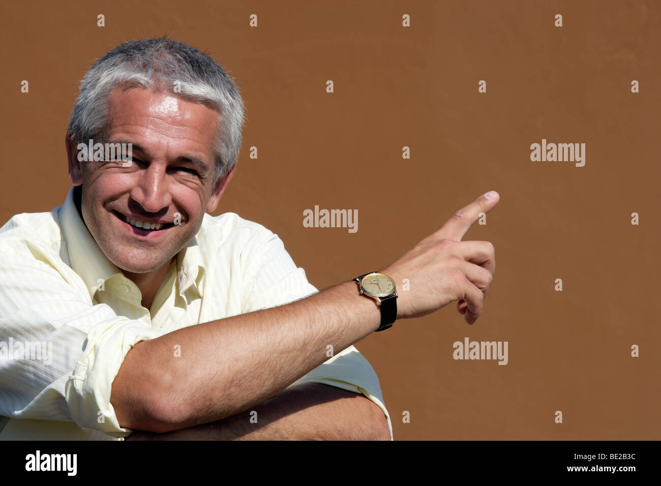 Portrait of happy businessman pointing Stock Photo - Alamy
