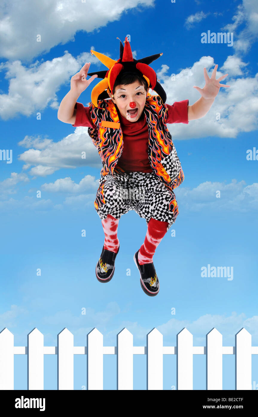 Child clown jumping fence with sky and clouds background Stock Photo ...
