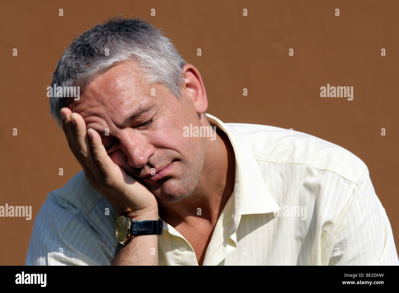 Portrait of sleepy man resting his head on hand Stock Photo - Alamy