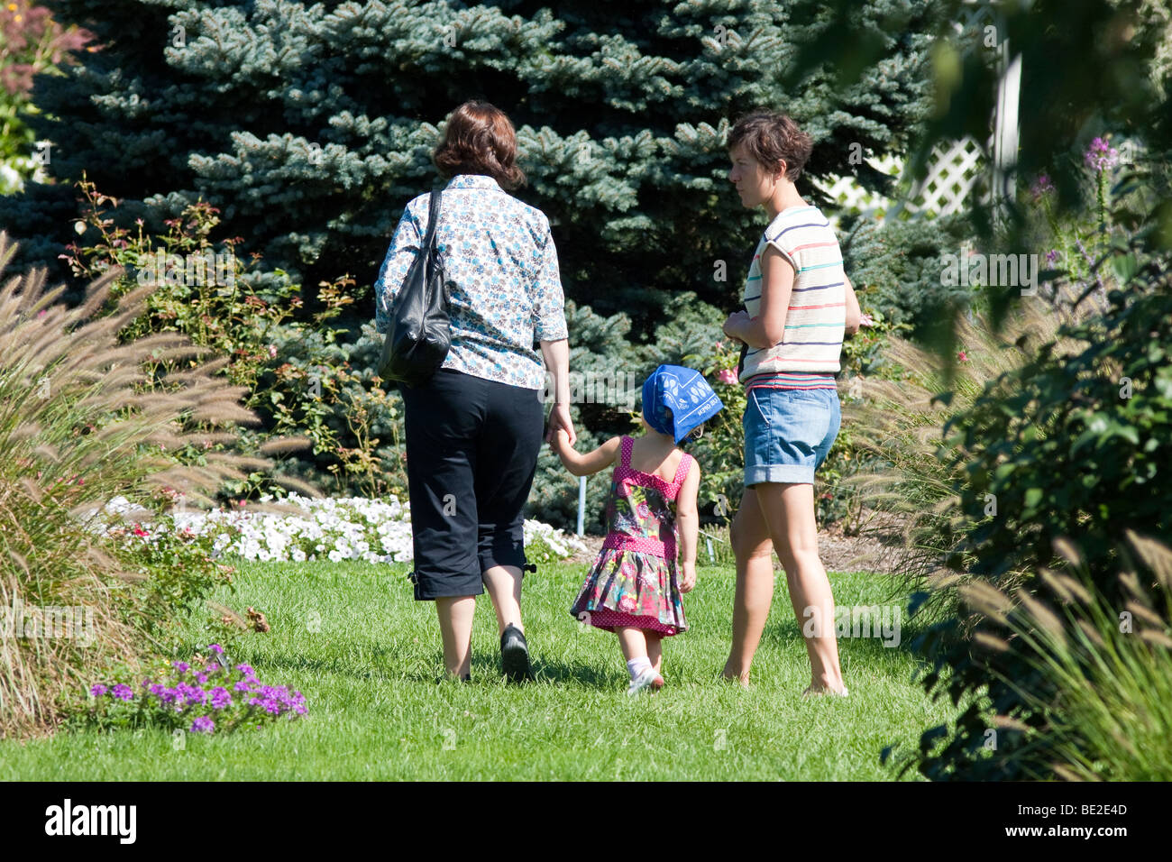 Two young women and a little girl walking in the park Stock Photo - Alamy