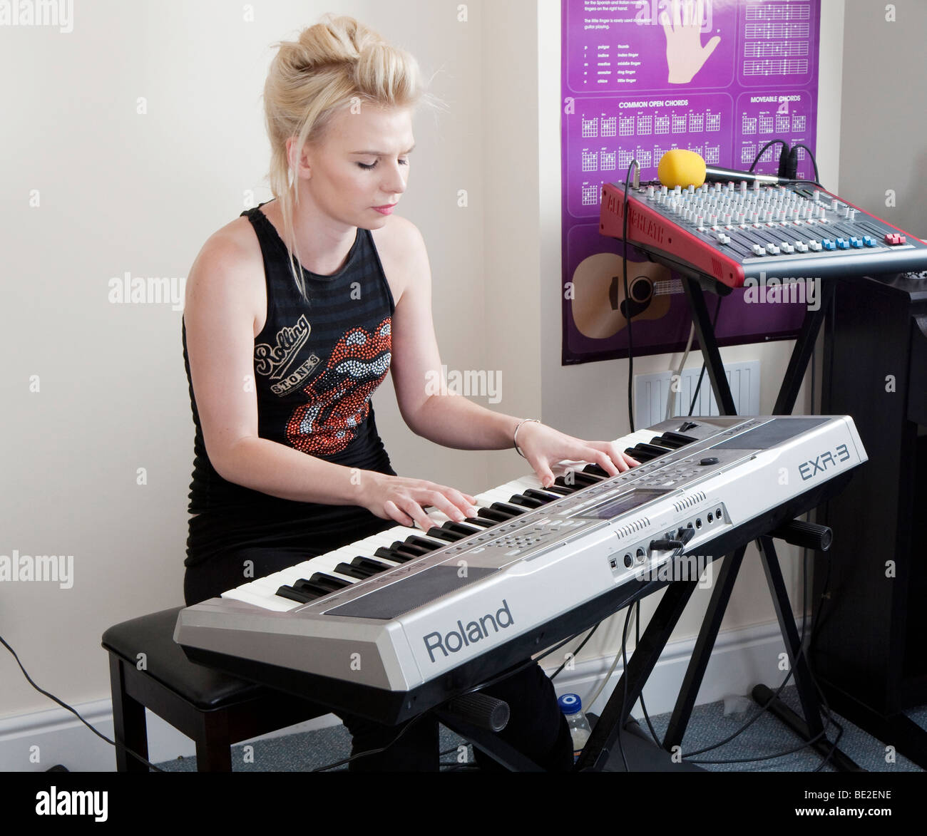 A young woman practicing playing on a keyboard in a studio Stock Photo ...