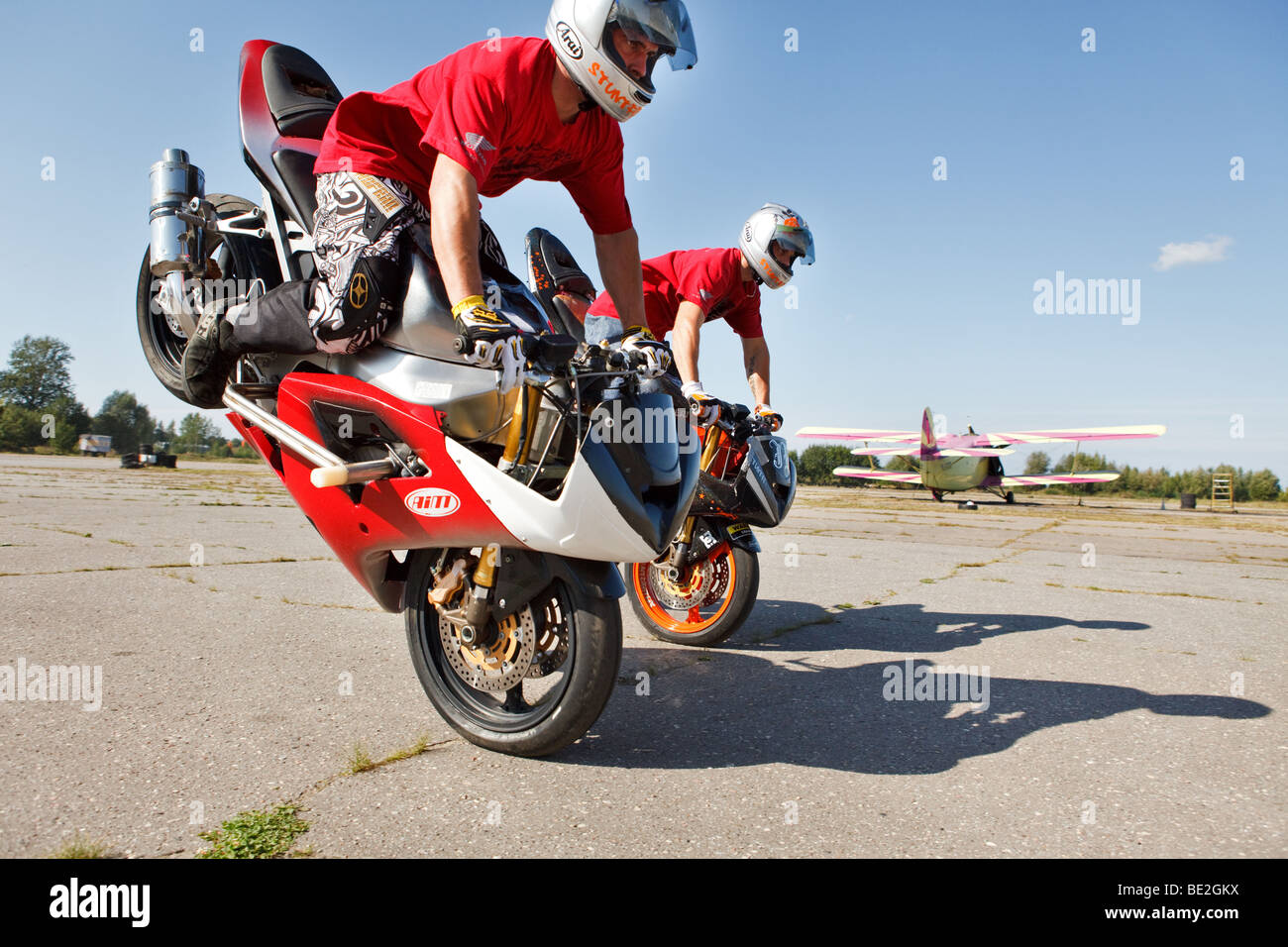 Two stunt riders making stoppie synchronously Stock Photo - Alamy