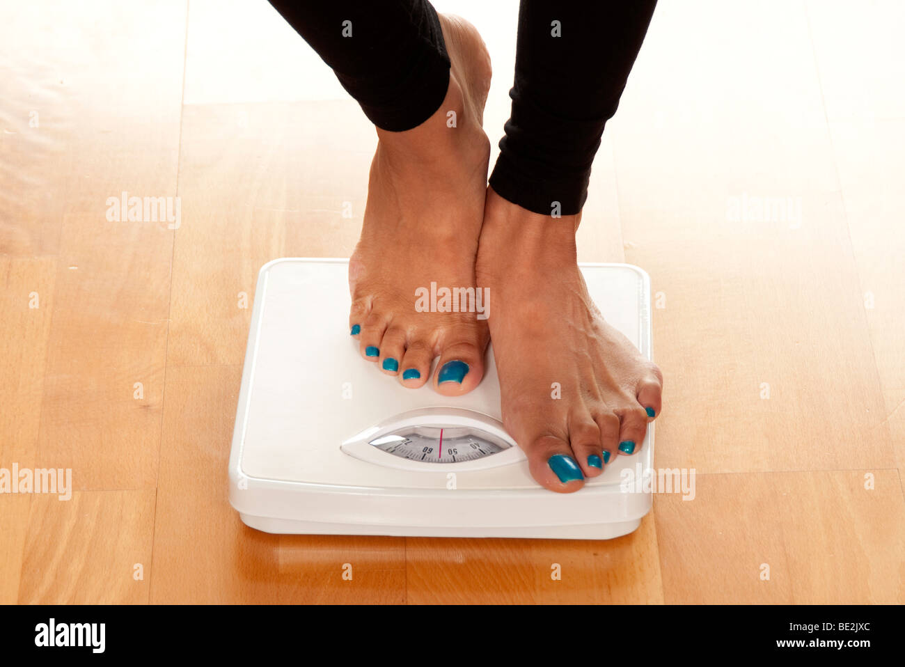 woman standing on scales Stock Photo - Alamy