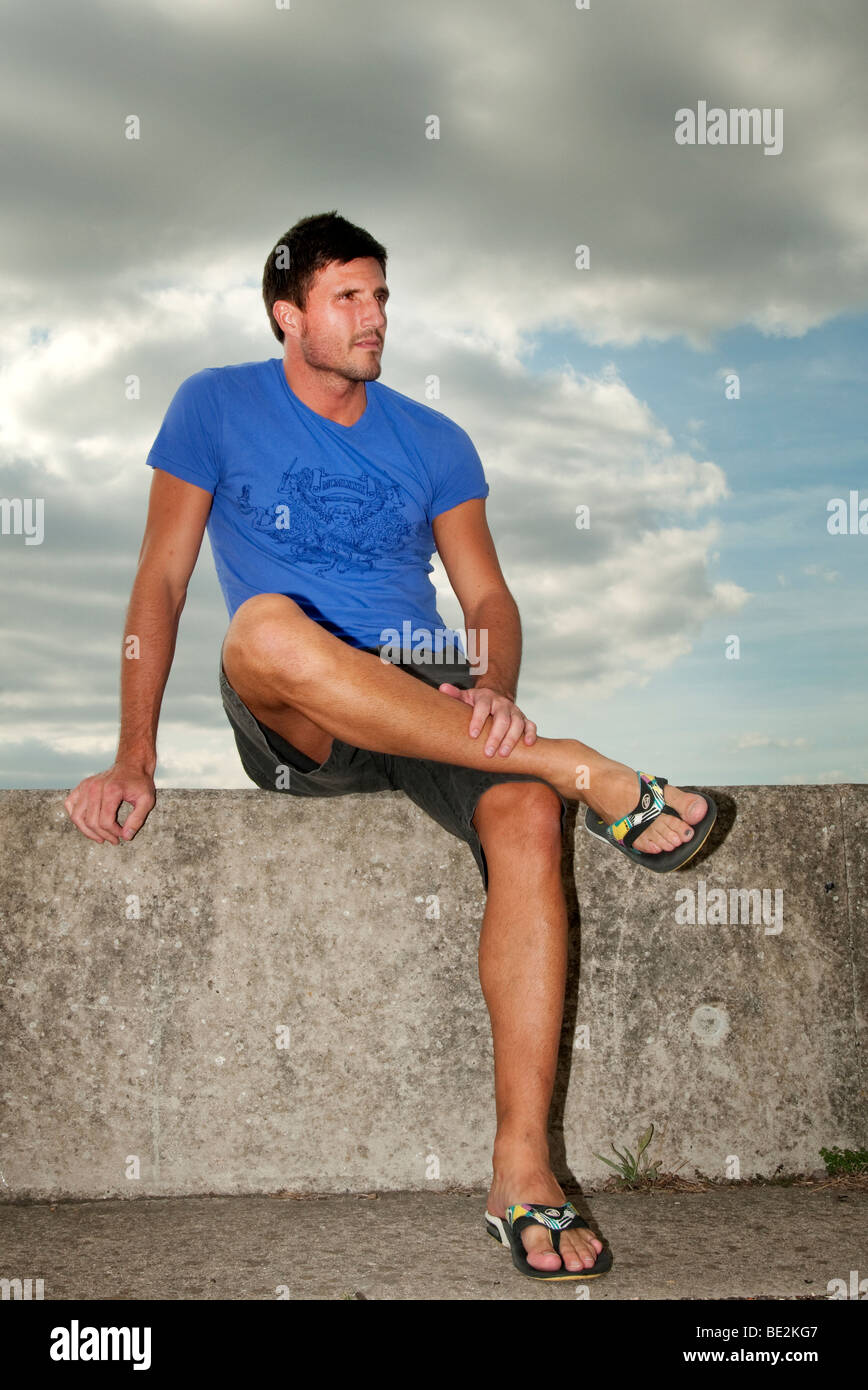 man sitting on a wall relaxing Stock Photo - Alamy