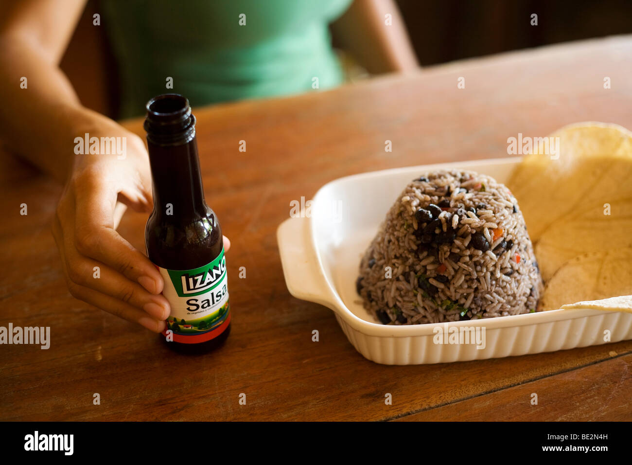 Lizano sauce being poured onto a plate of Gallo Pinto, a typical and ...