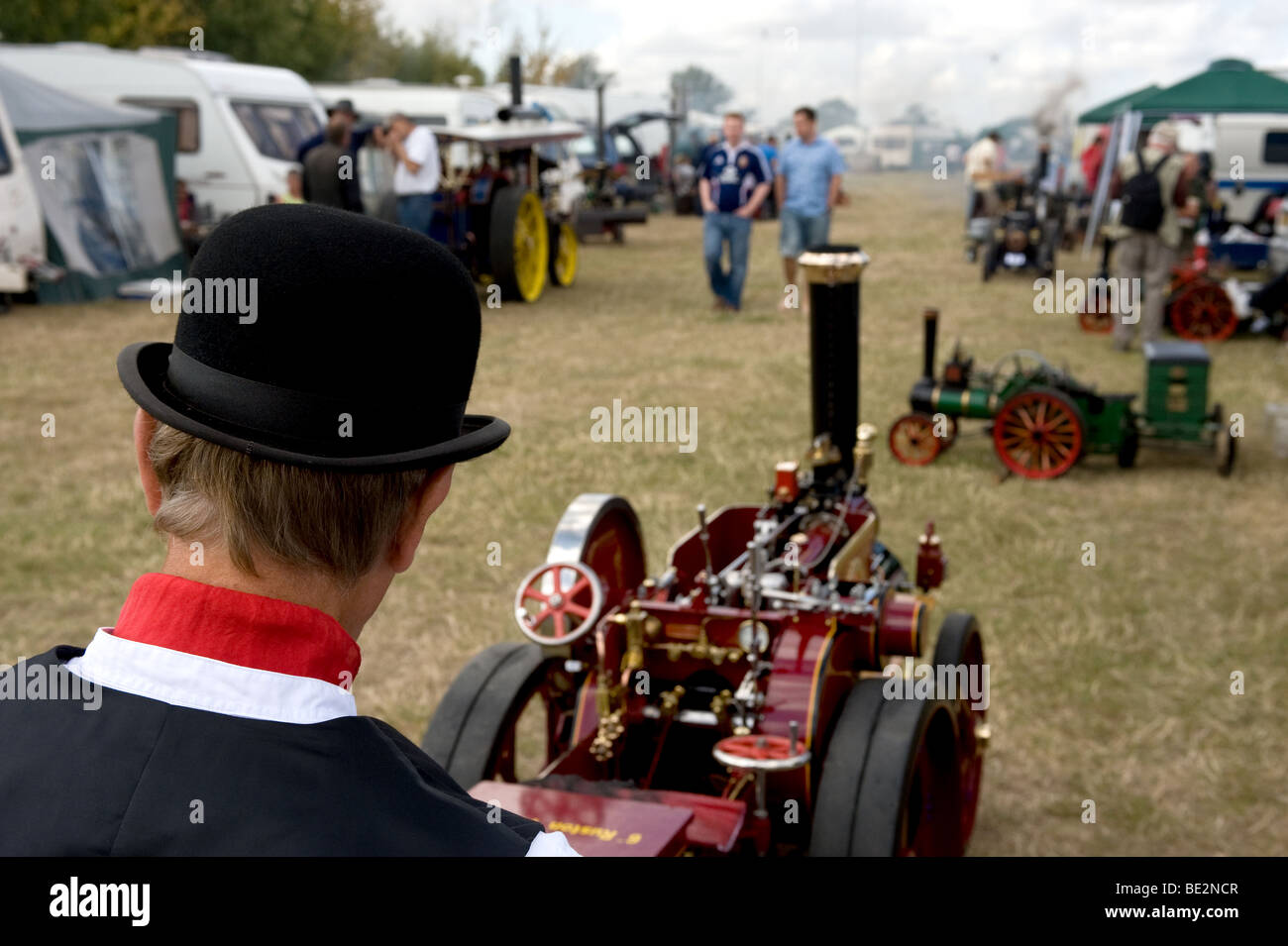 The owner of a miniature steam traction engine sitting on its driving ...