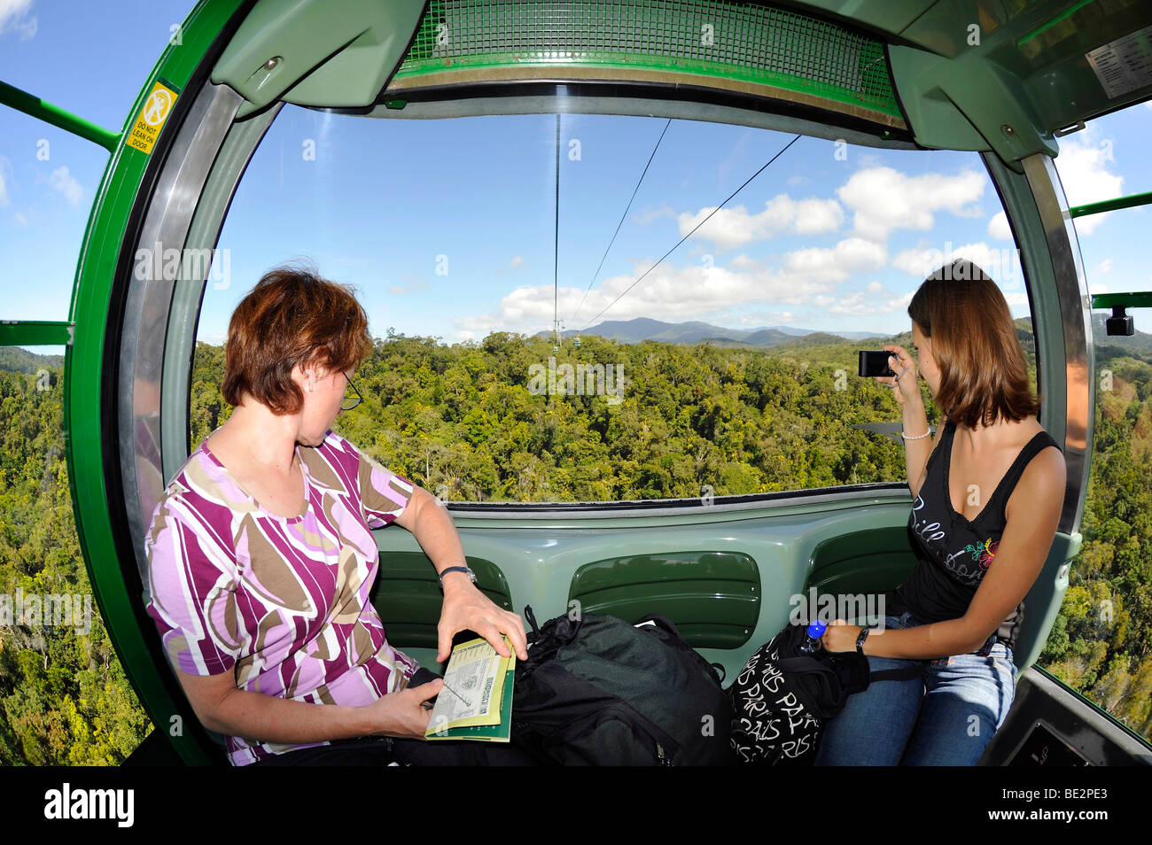 Passengers on the Skyrail Rainforest Cableway, the longest cable car of ...