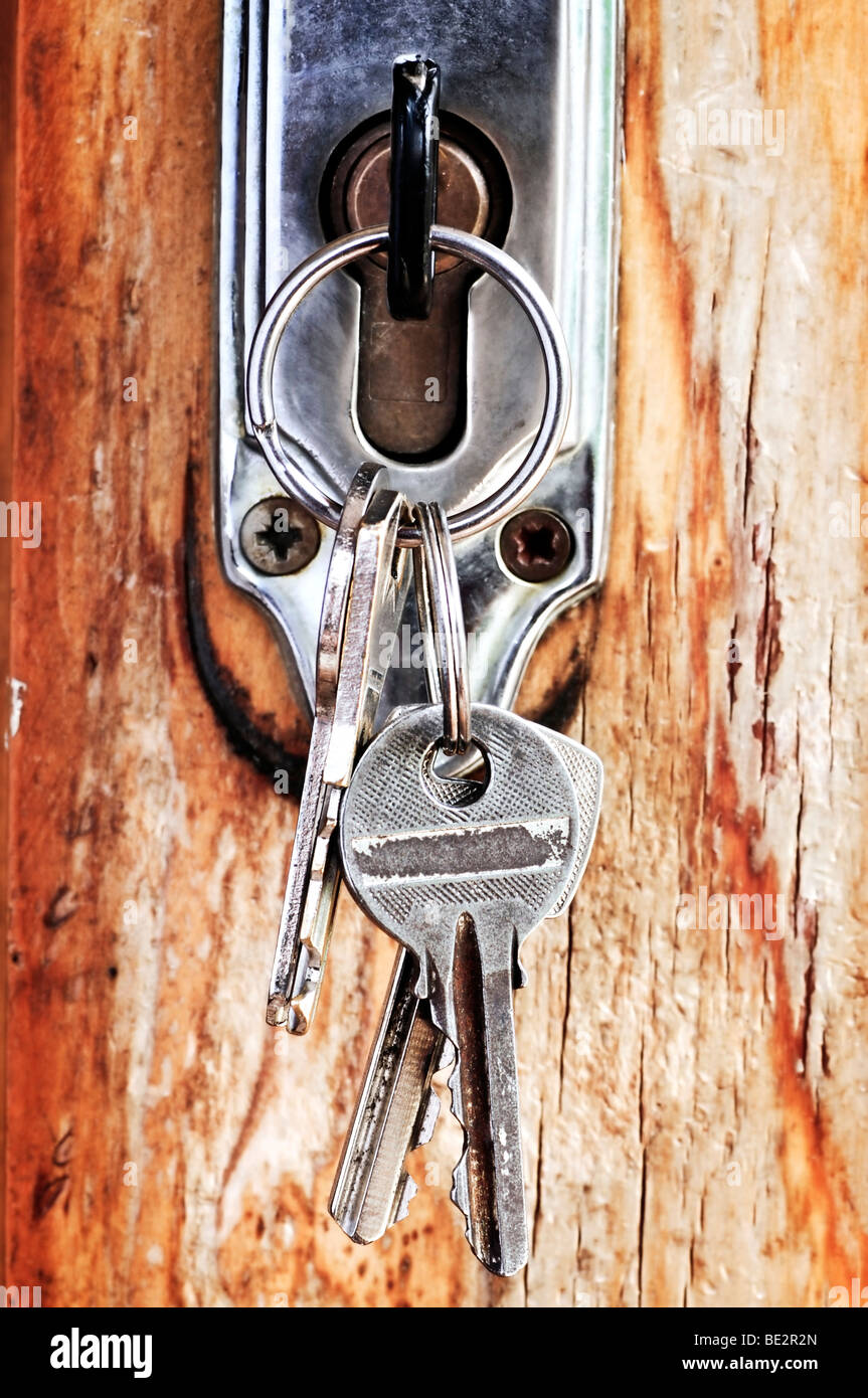 Set of keys in lock of old wooden door Stock Photo - Alamy