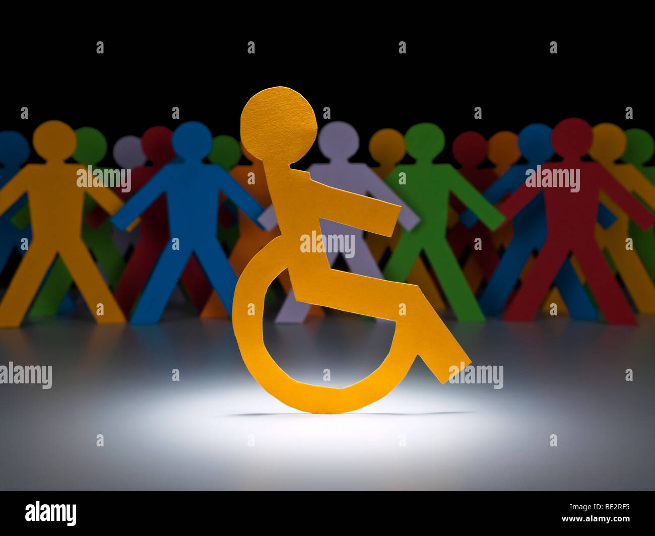 A disable paper figure stands under the spotlight on his wheelchair ...