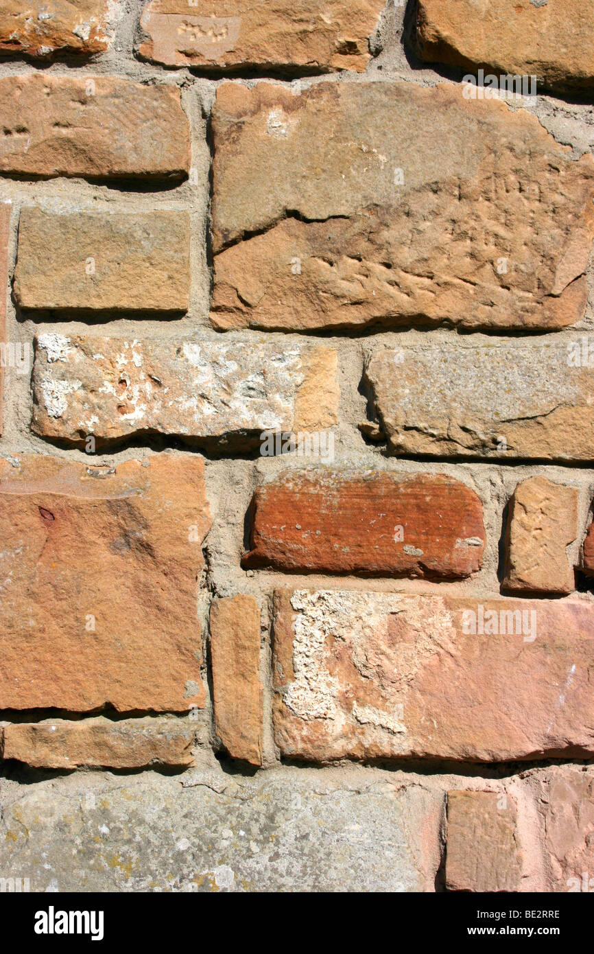 Warm sandstone colours of an old stone cottage wall in the sunlight ...