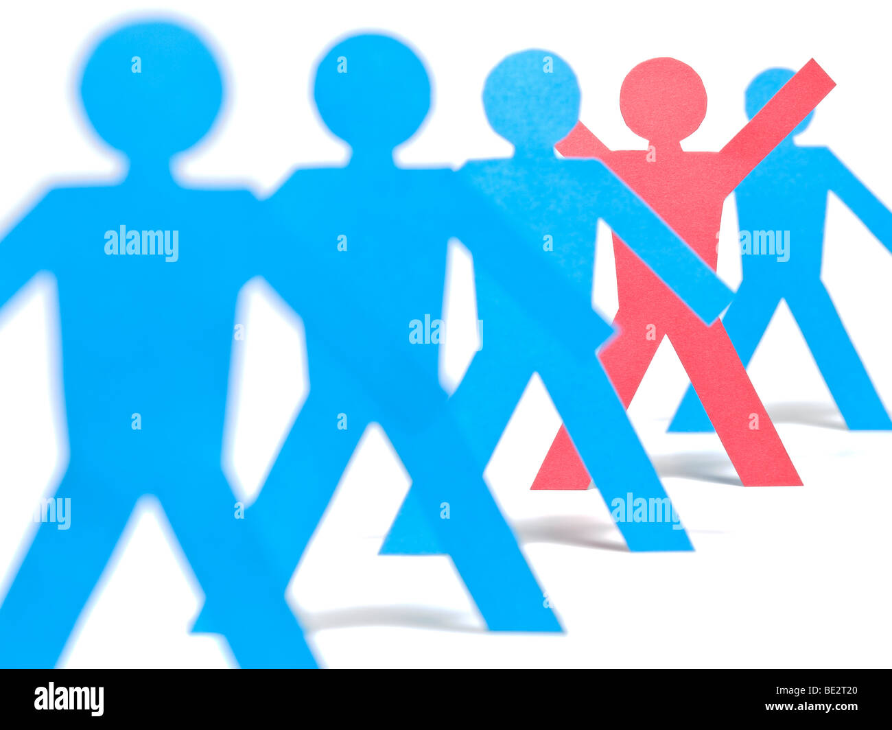 A red paper figure is raising his arms in the blue paper figures line ...