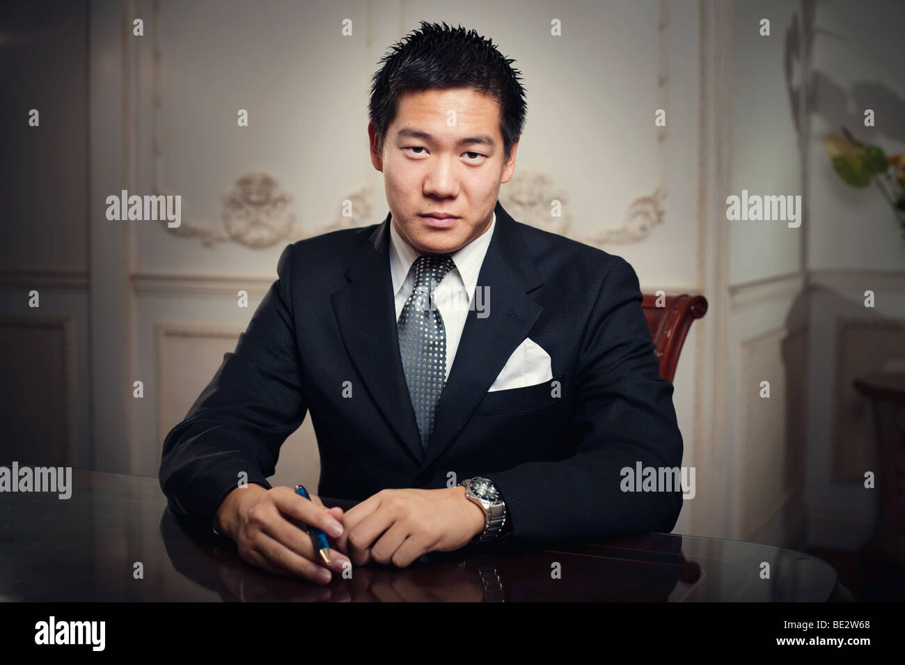 An Asian male in a suit poses for a portrait Stock Photo - Alamy