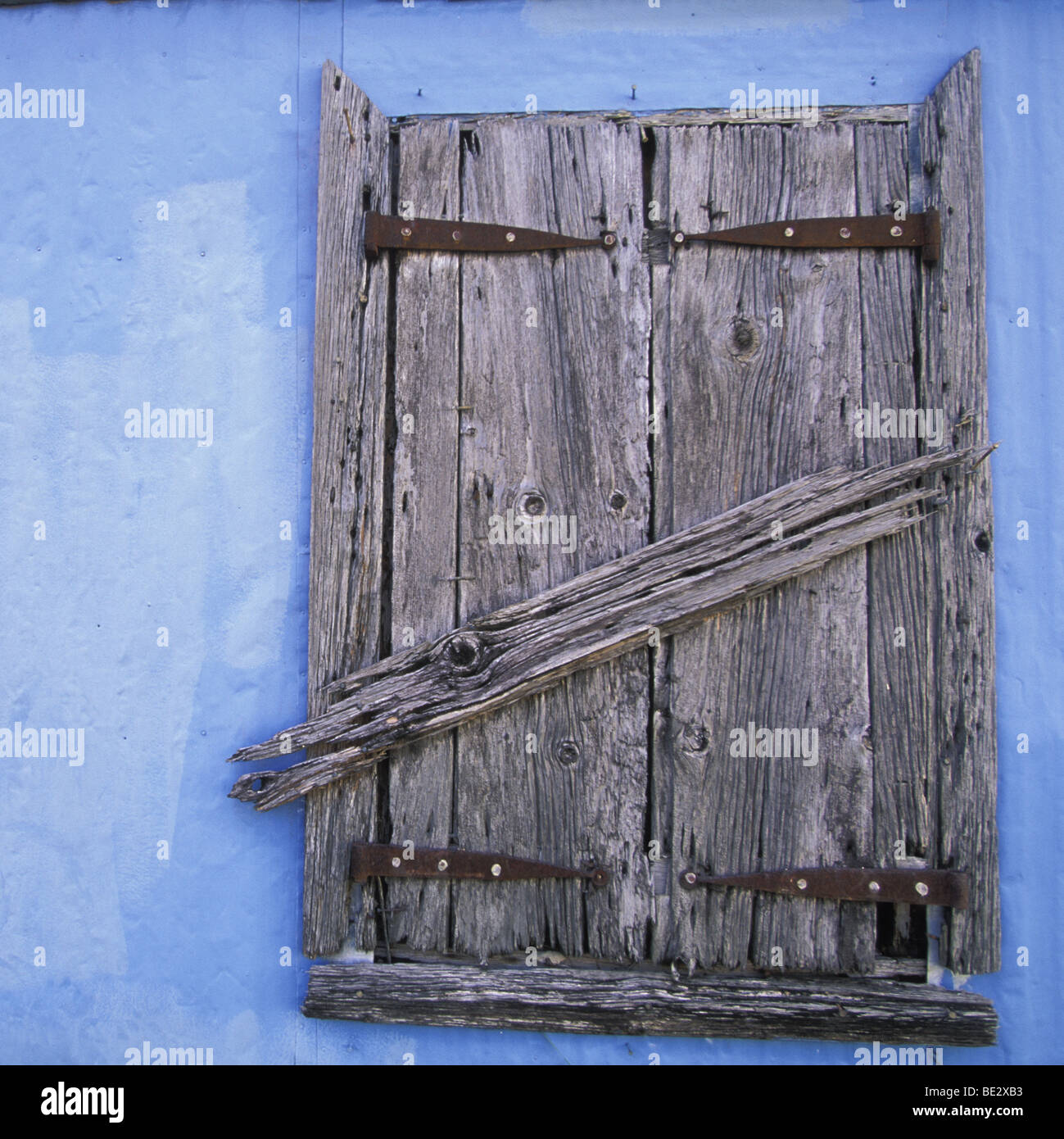 Wooden window shutters on blue wall Stock Photo - Alamy