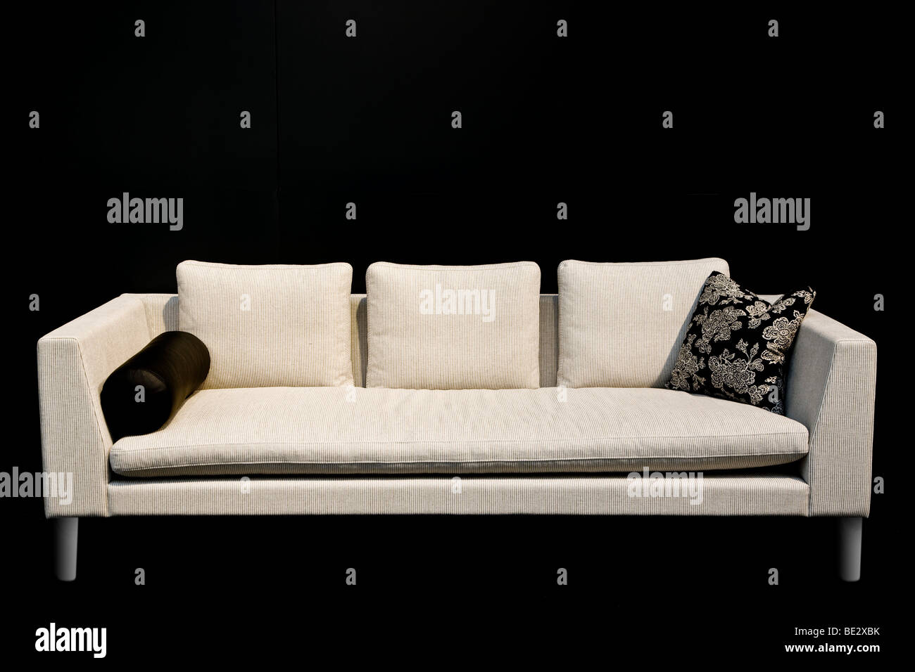 White designer sofa against black backdrop Stock Photo - Alamy