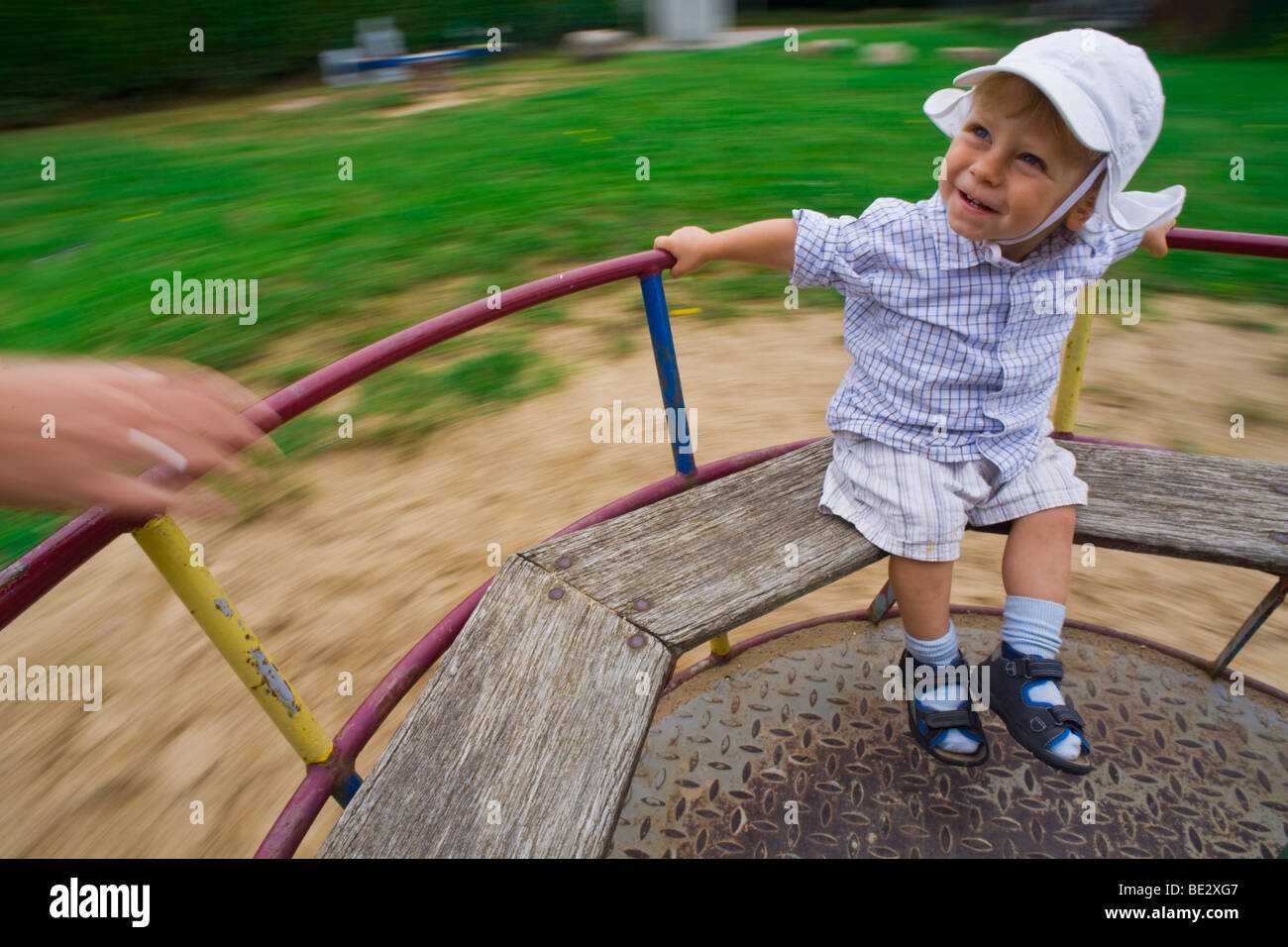 Boy, 18 months, riding a carousel Stock Photo - Alamy