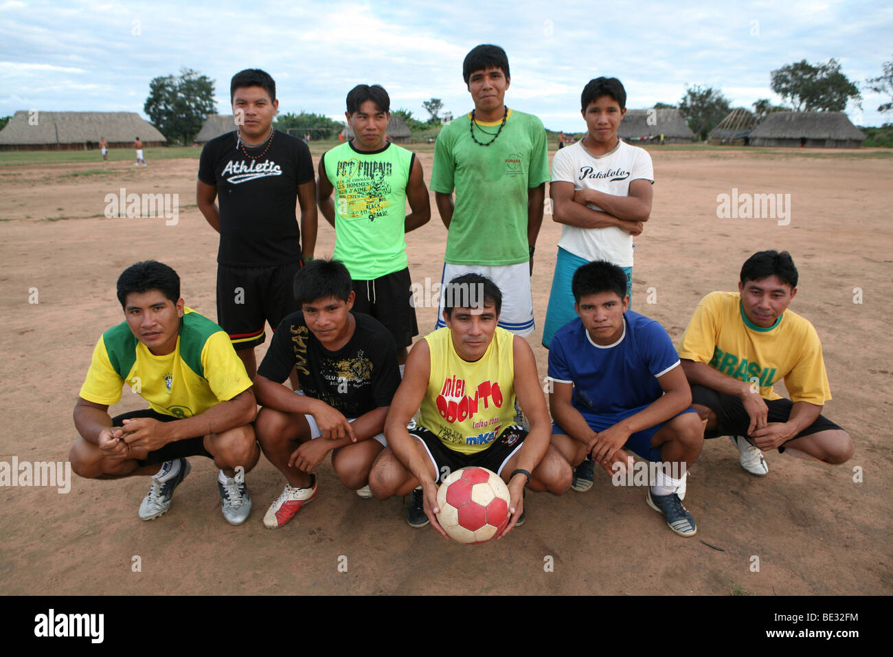 Xingu indians are playing football at the village square. The are ...