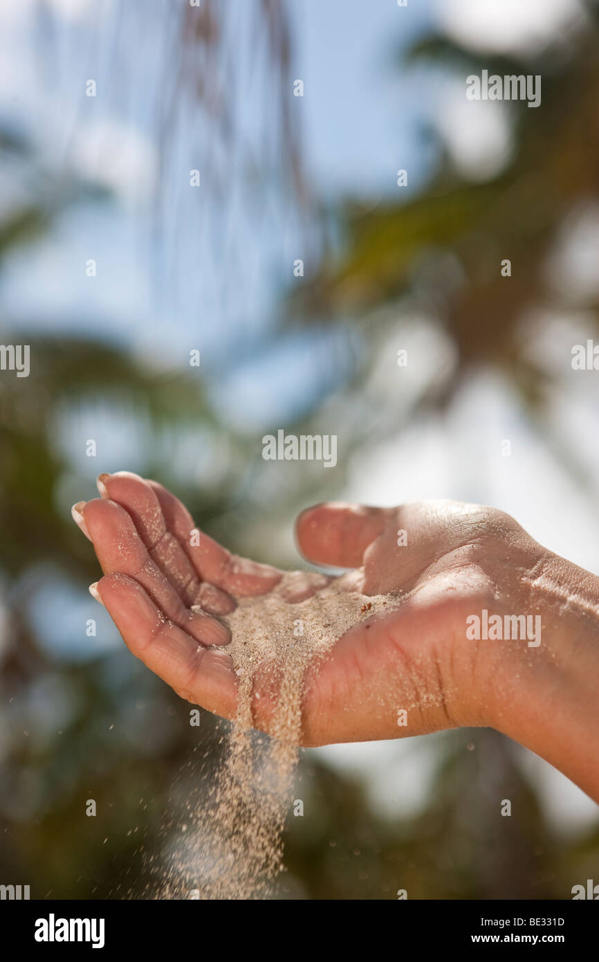 Coral sand is trickling through a woman's fingers Stock Photo - Alamy