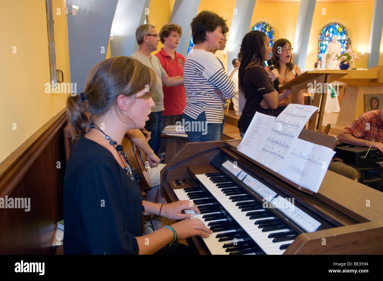 Keyboard player and group of young people singing in church Stock Photo ...