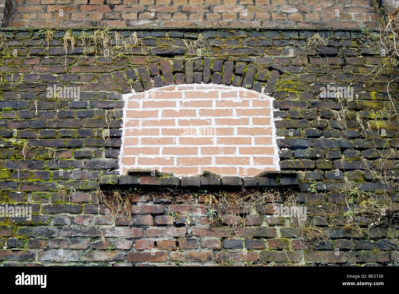 Small window in an old brick wall, freshly sealed with bricks as ...