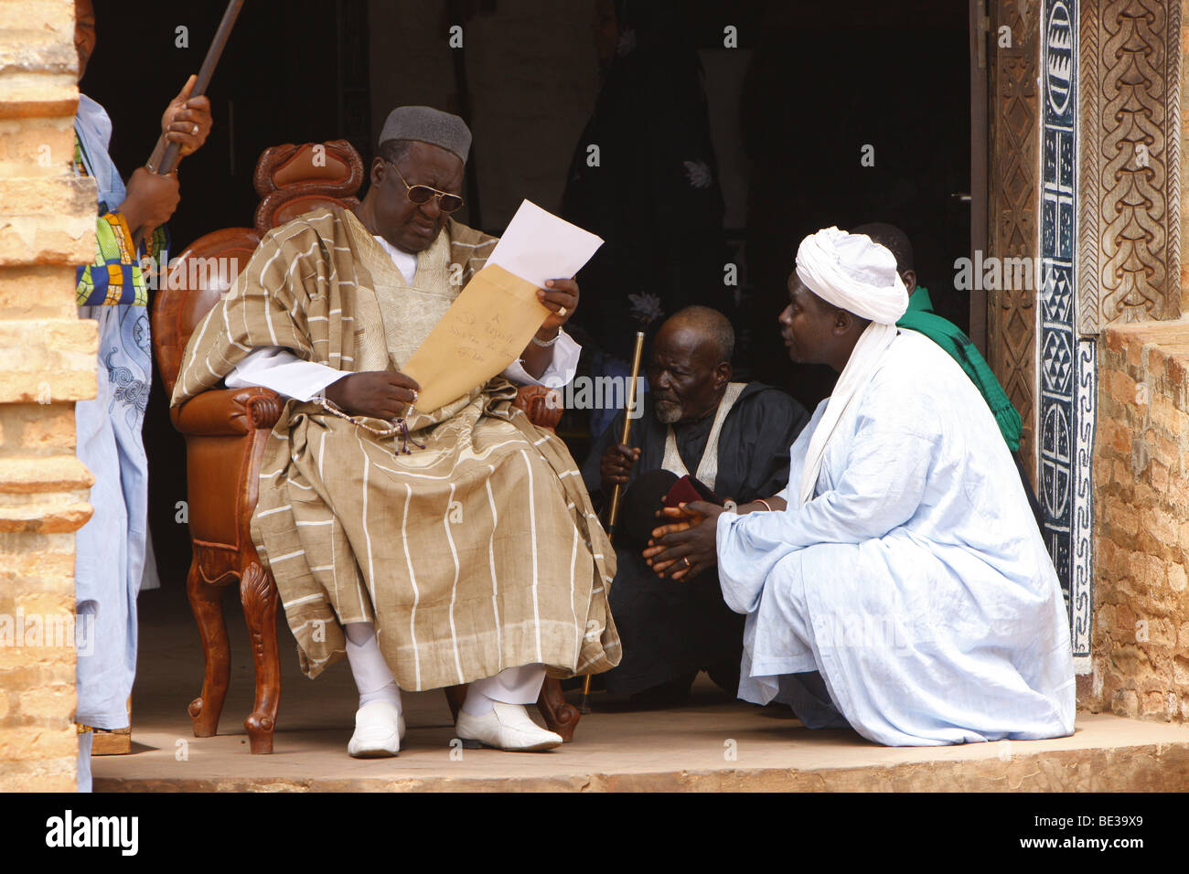 Sultan Ibrahim Mbombo Njoya in front of the Sultan's palace, holding an ...