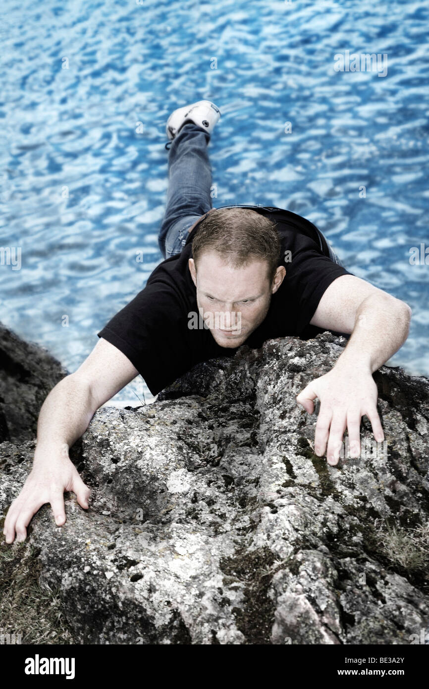 Young man climbing Stock Photo - Alamy